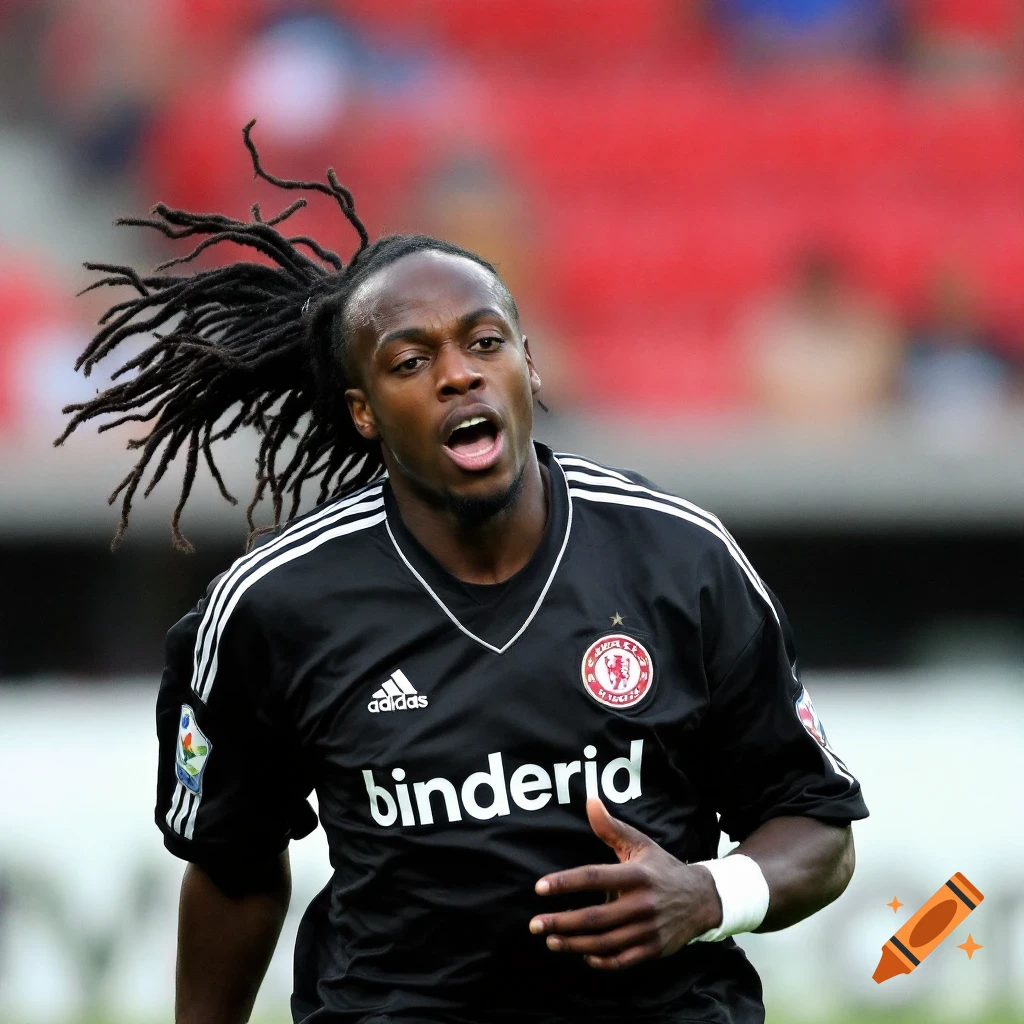 A male soccer player with dreadlocks wears a black and white jersey ...