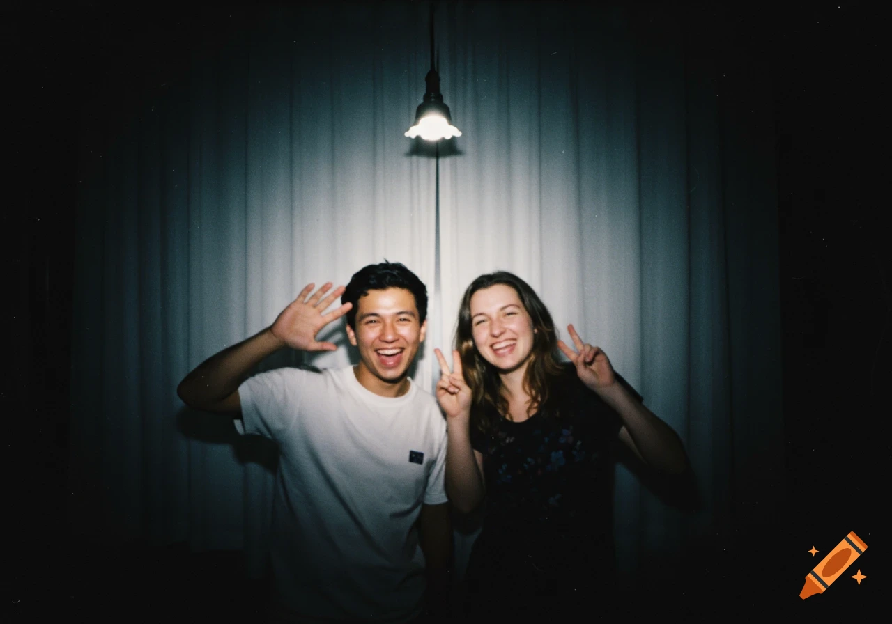 Two smiling young people, a man waving and a woman making a peace sign ...